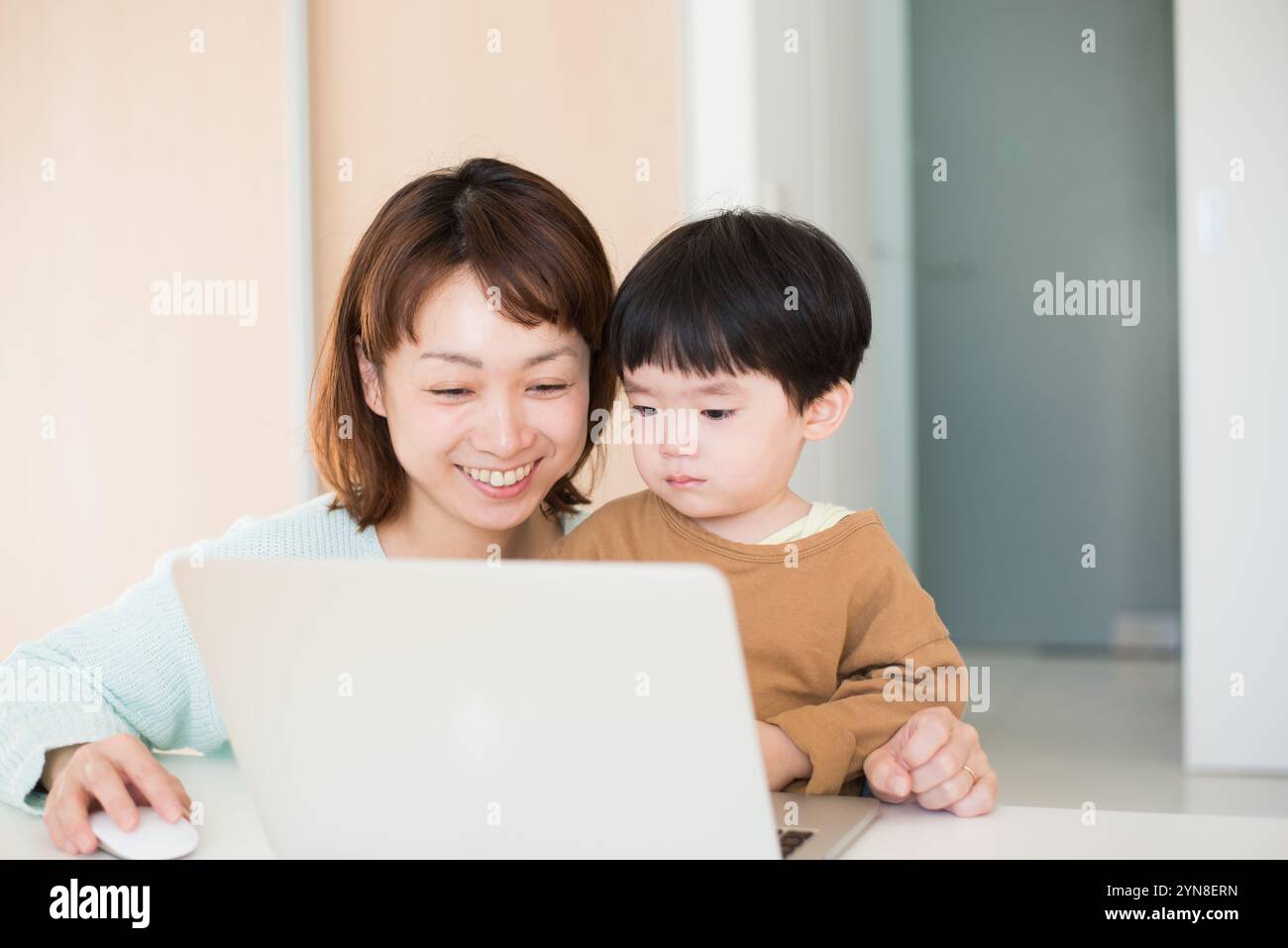 Parent and child looking at computer Stock Photo - Alamy