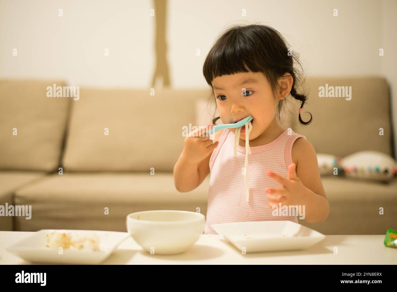 Girl eating udon noodles Stock Photo - Alamy