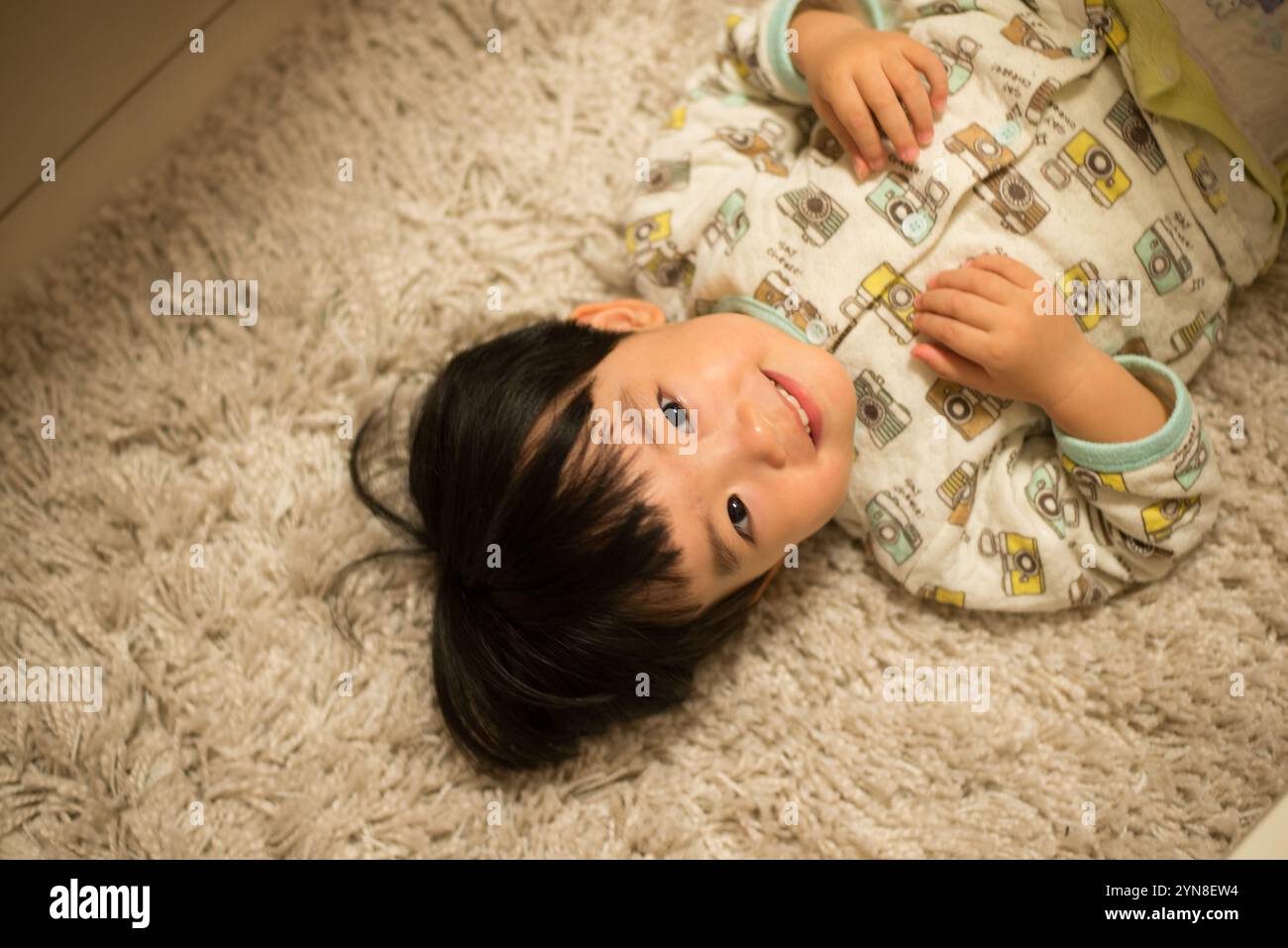 Boy lying on carpet Stock Photo - Alamy
