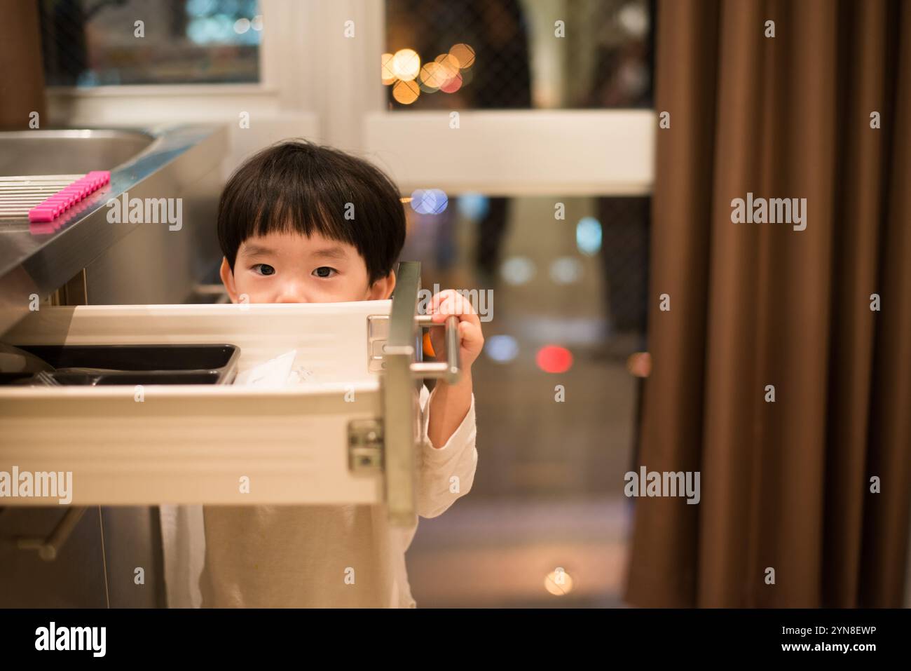 Boy playing in kitchen Stock Photo - Alamy