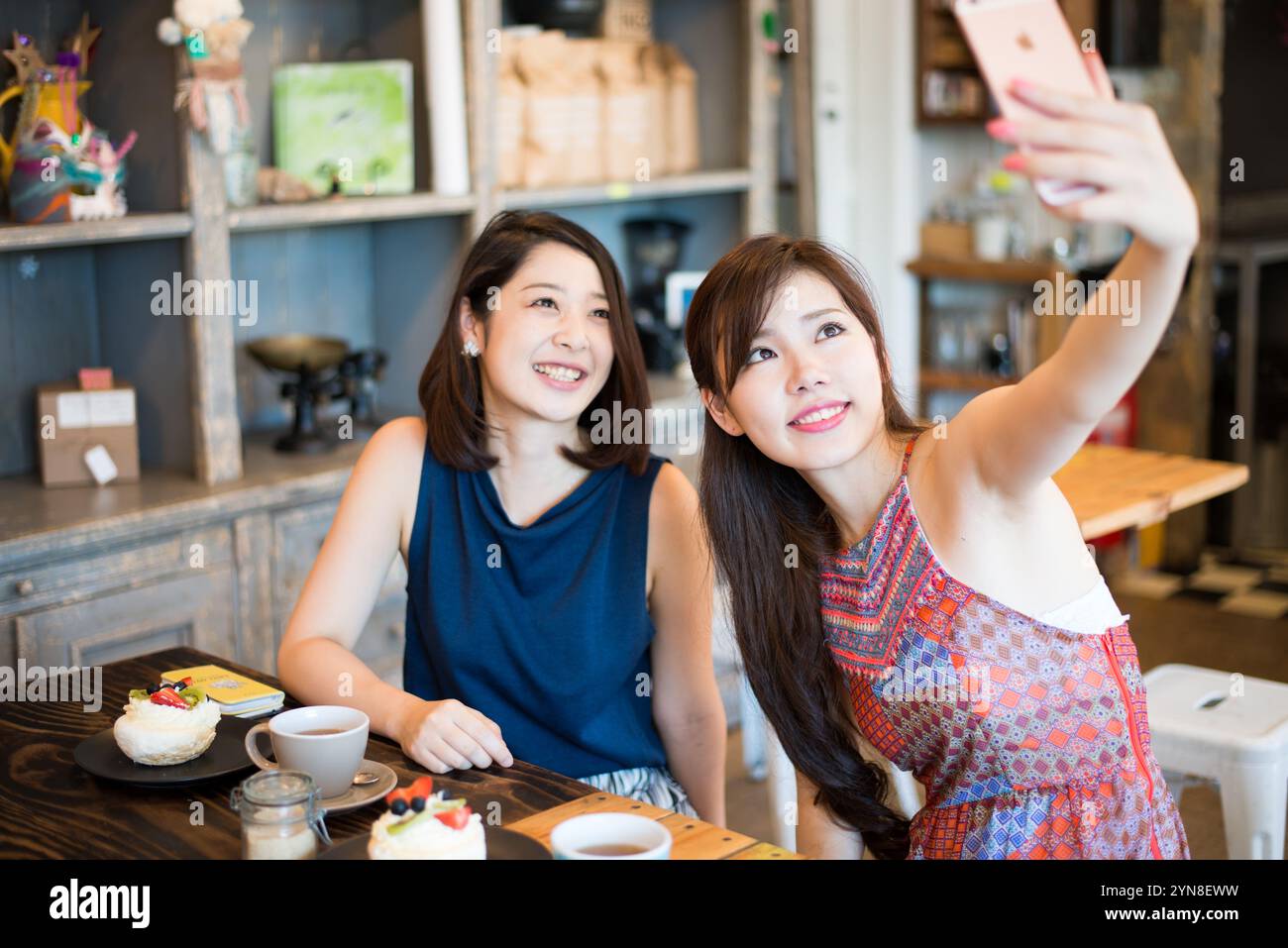 Two people taking selfies in a café Stock Photo - Alamy