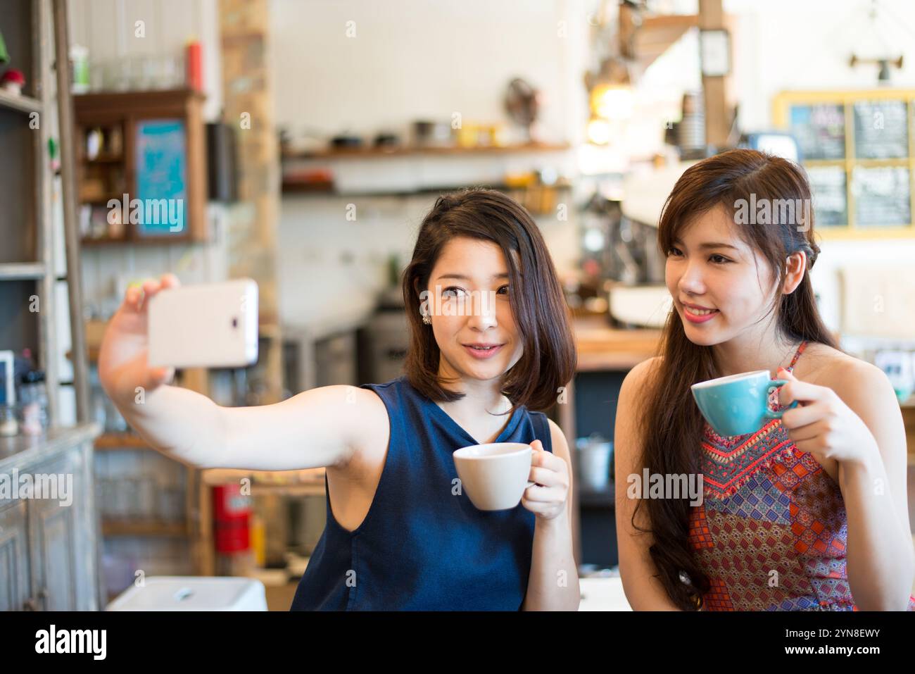 Two people taking selfies in a café Stock Photo - Alamy