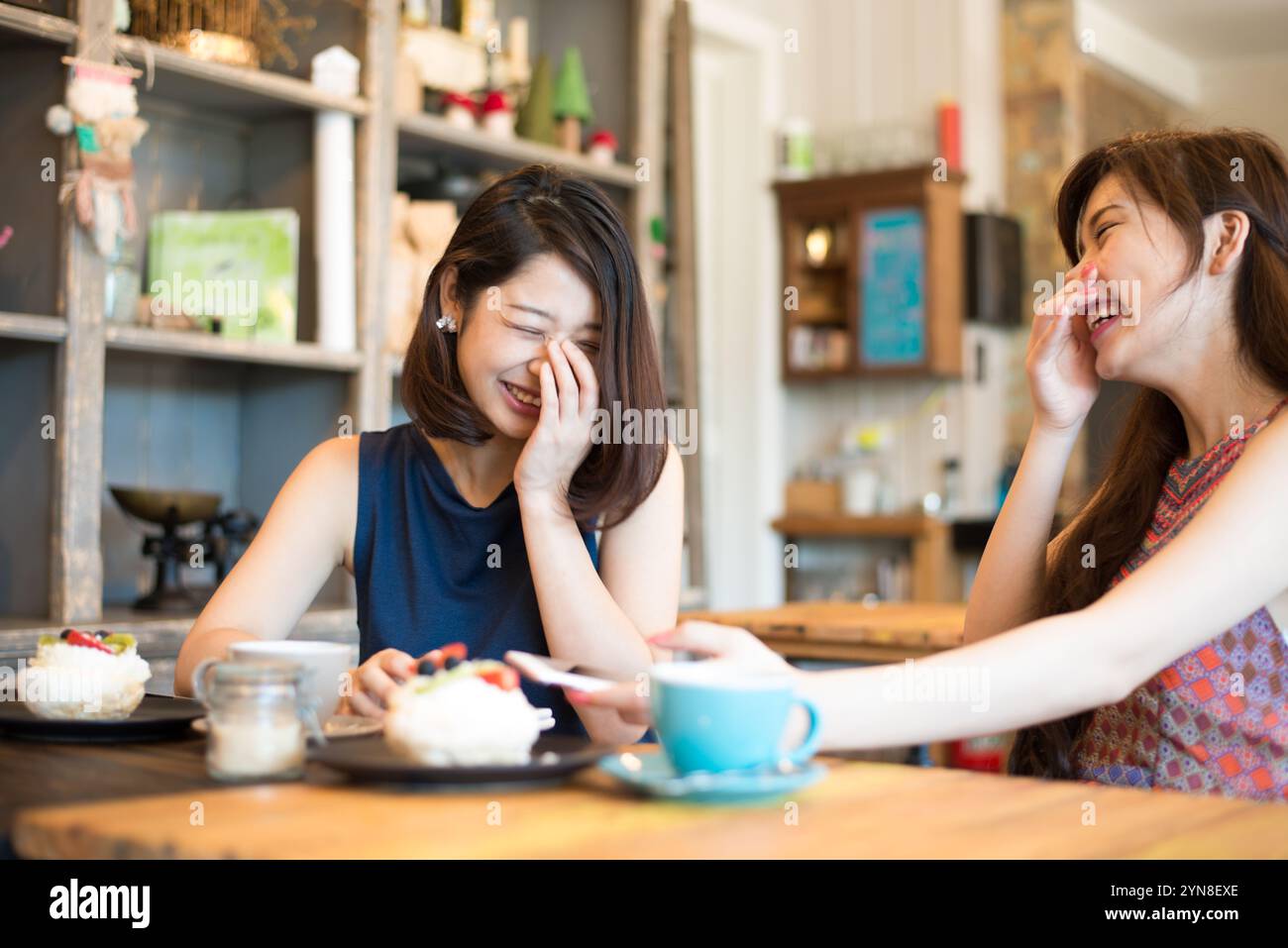 Two people laughing at the café Stock Photo - Alamy