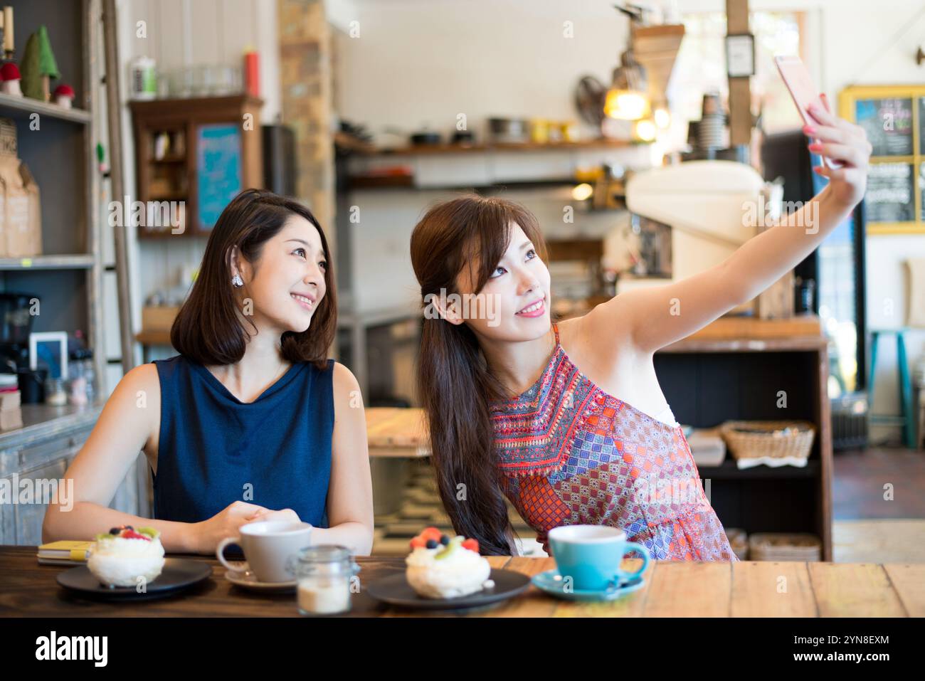 Two people taking selfies in a café Stock Photo - Alamy