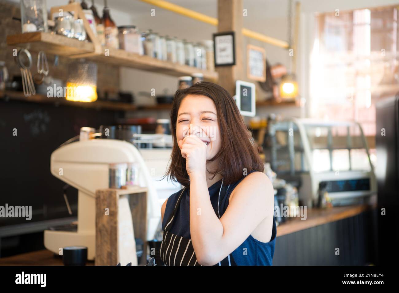 A waitress laughing at the café Stock Photo - Alamy