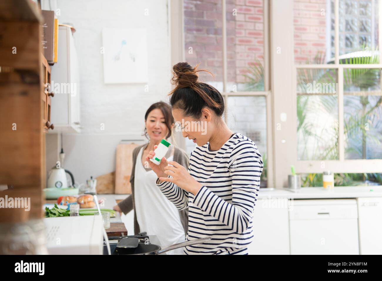 Two women cooking in kitchen Stock Photo - Alamy