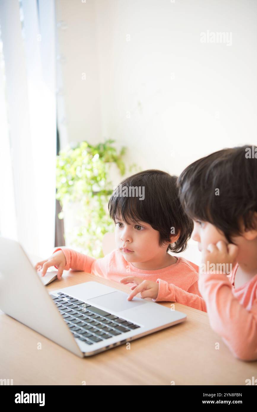 Twin boys operating a computer Stock Photo - Alamy