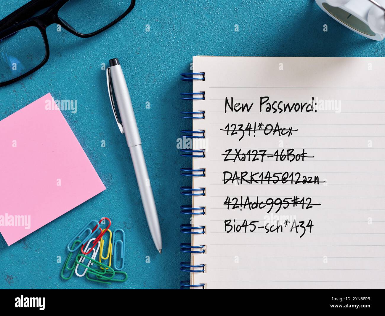 Changing password or password renewal. Notebook showing new passwords with office supplies on ...