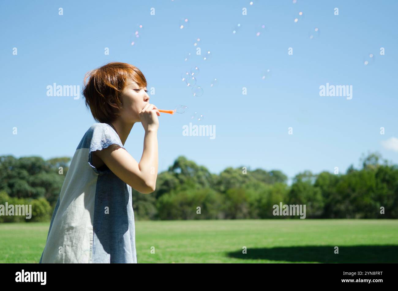 Woman blowing soap bubbles outdoors hi-res stock photography and images ...