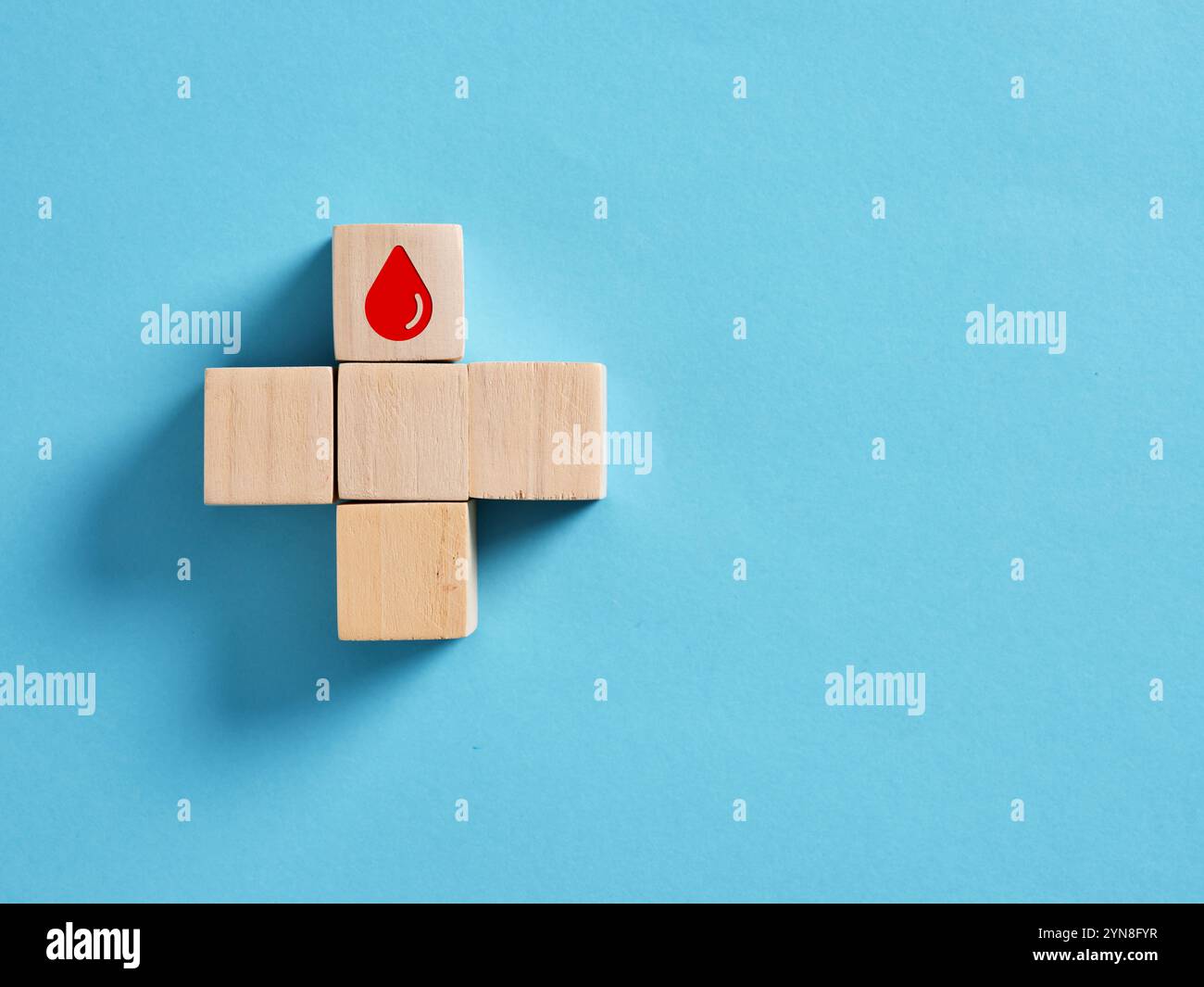 Wooden cubes forming a plus symbol with a blood drop on top ...