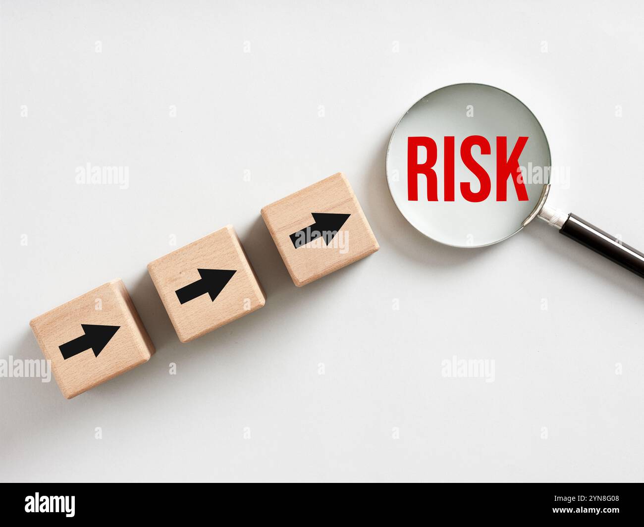 Magnifying glass showing risk word with wooden cubes and arrows ...