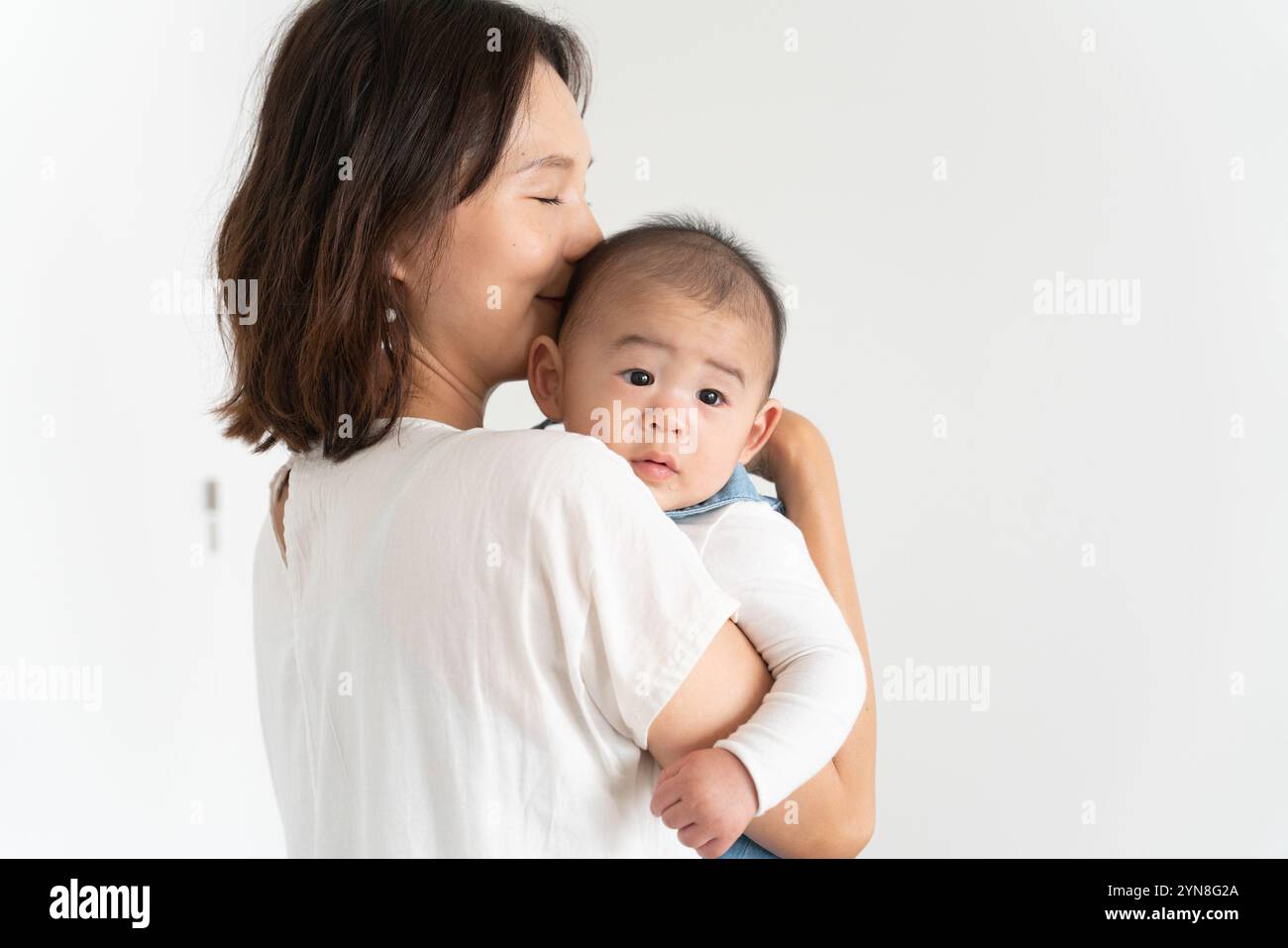 Mother carrying baby boy Stock Photo - Alamy