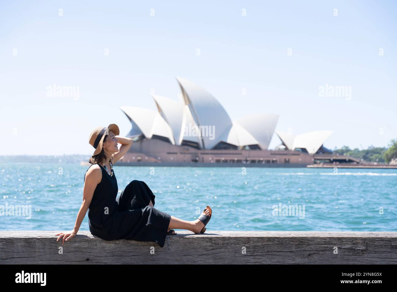 Woman sitting with opera house in background Stock Photo - Alamy