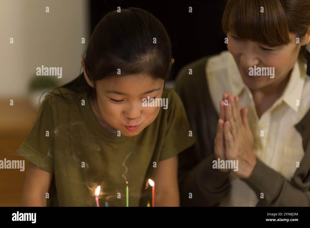Girl blowing out a candle Stock Photo - Alamy