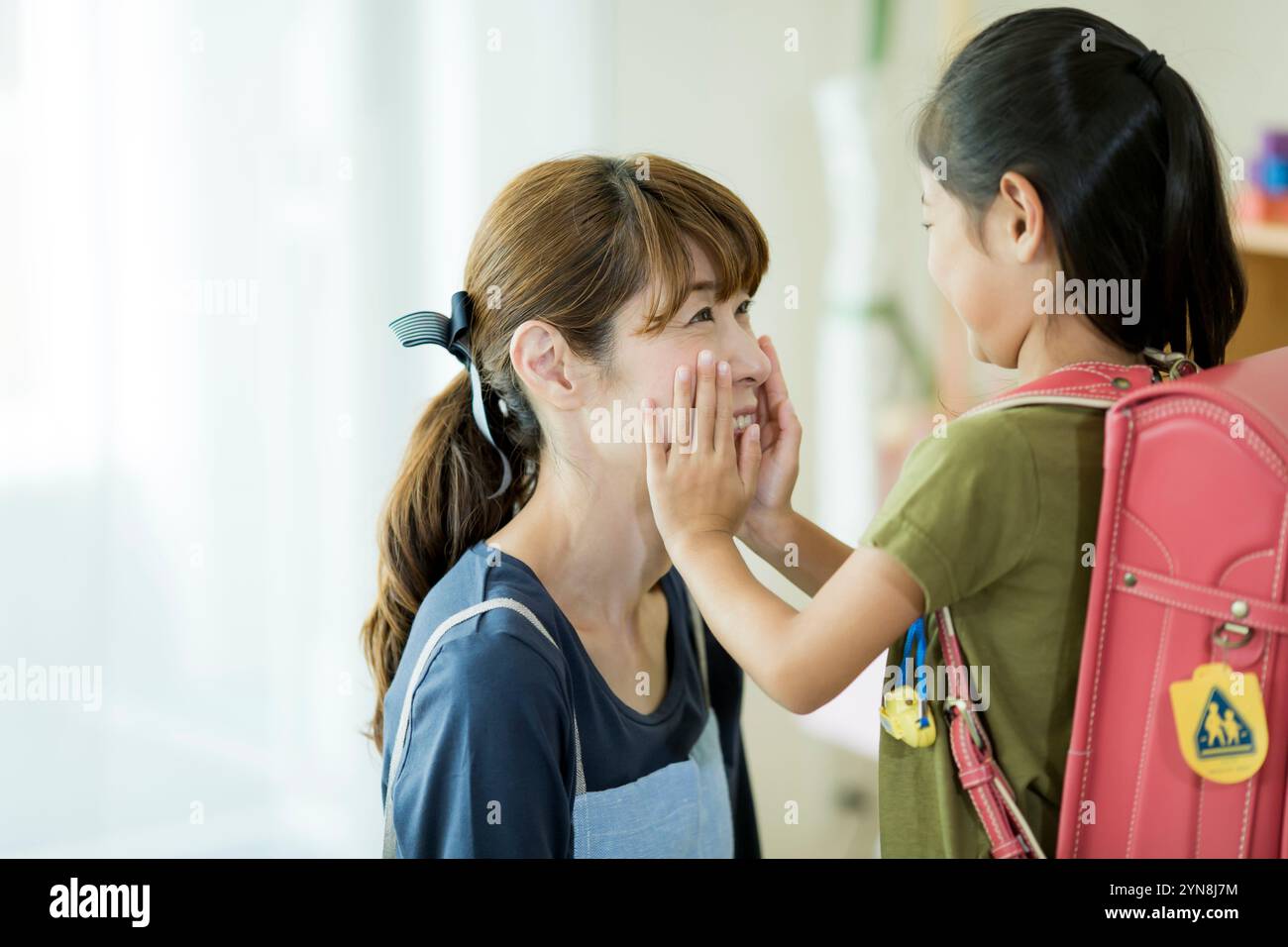 Parent and child facing each other smiling Stock Photo - Alamy