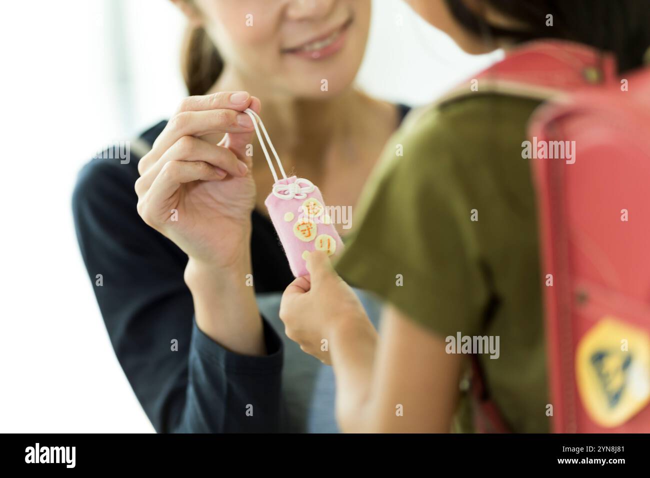 Mother giving her daughter a good-luck charm Stock Photo - Alamy