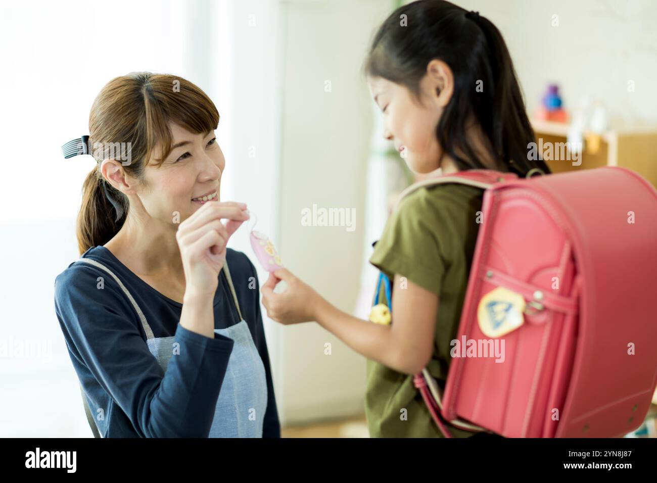Mother giving her daughter a good-luck charm Stock Photo - Alamy