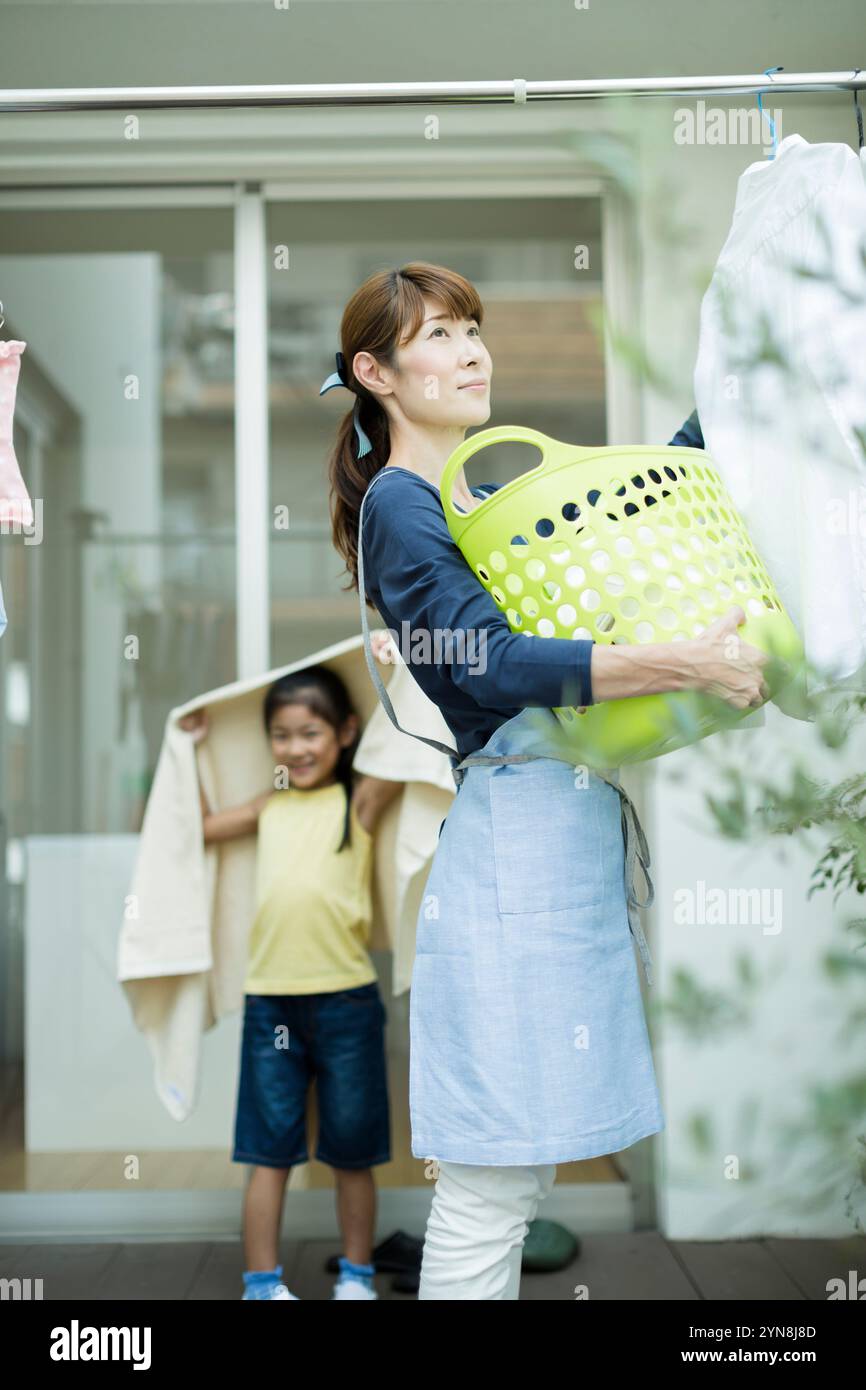 Parent and child drying laundry Stock Photo - Alamy