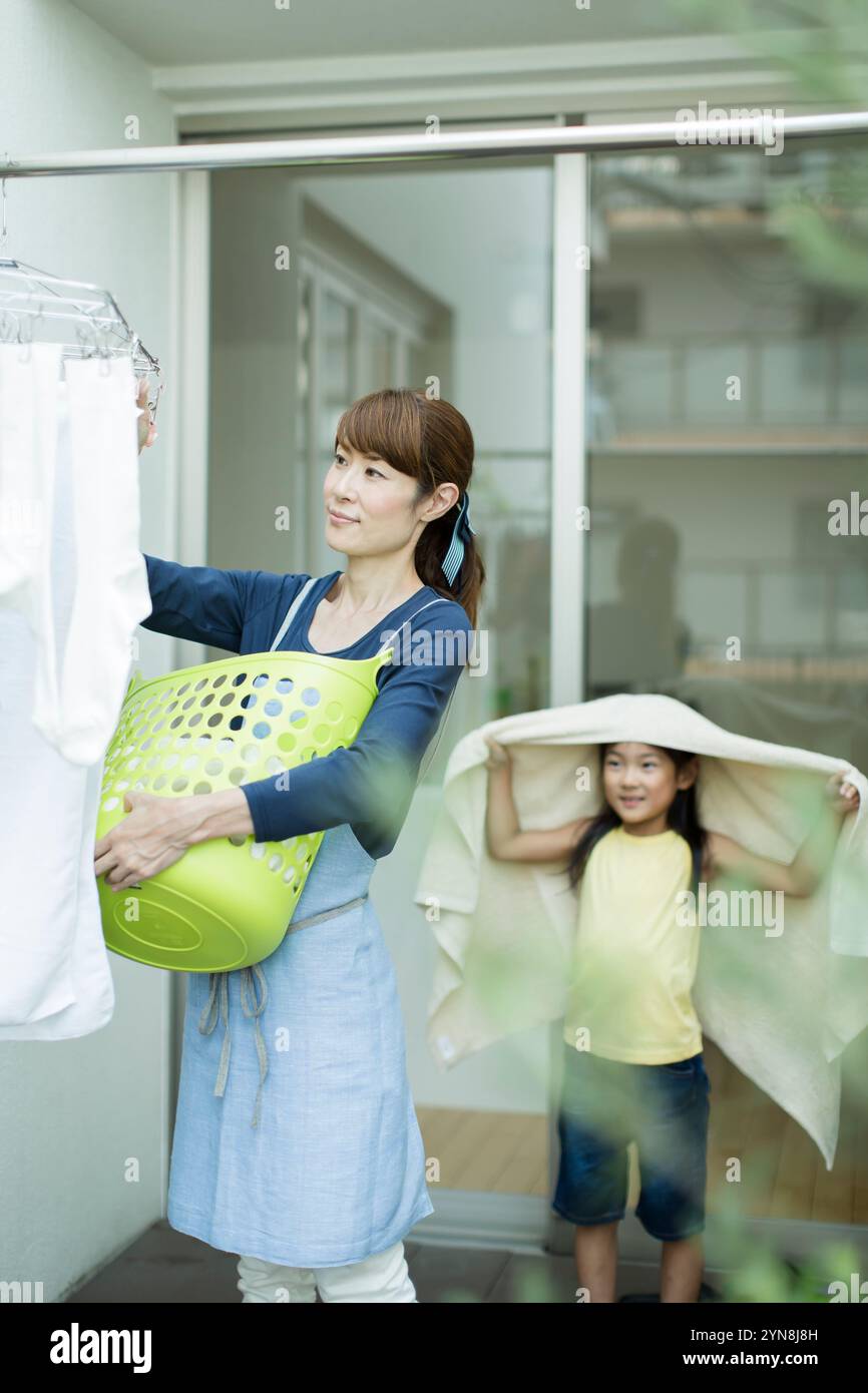 Parent and child drying laundry Stock Photo - Alamy