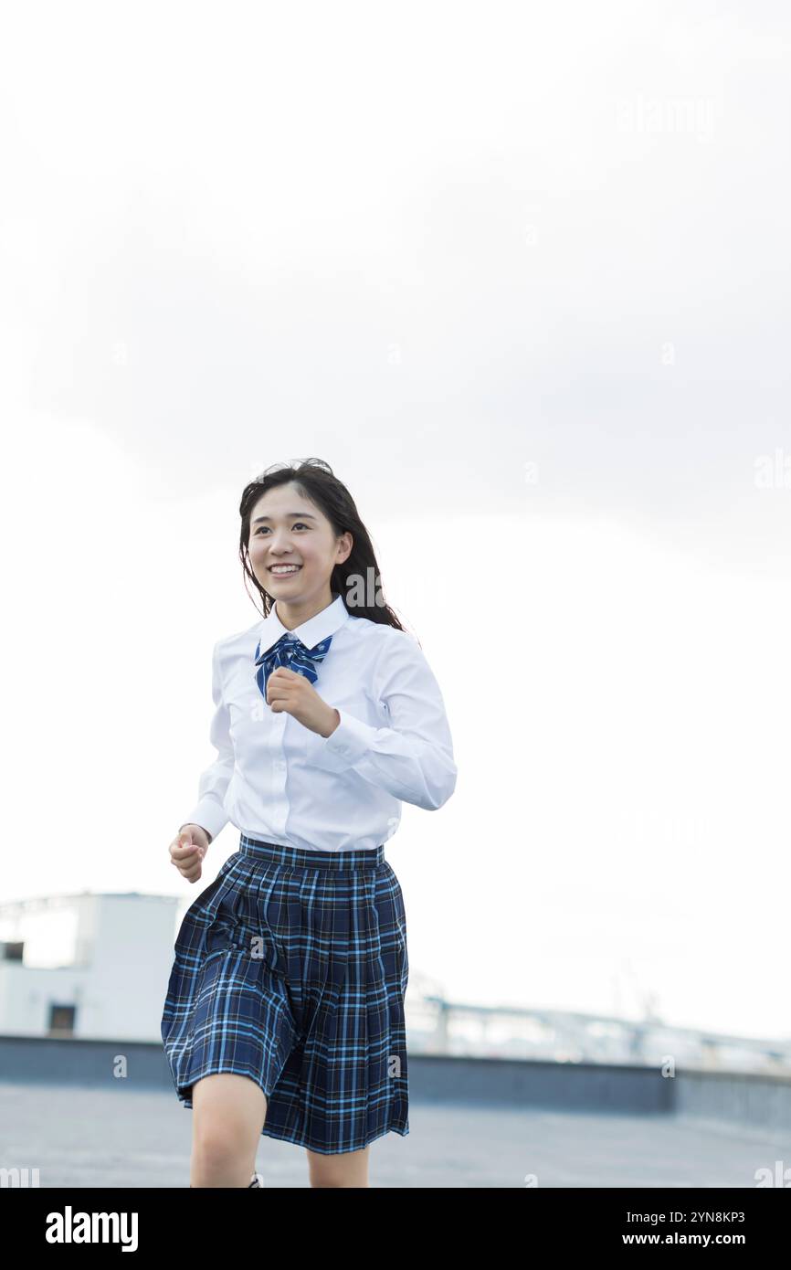 Female student running on rooftop Stock Photo - Alamy
