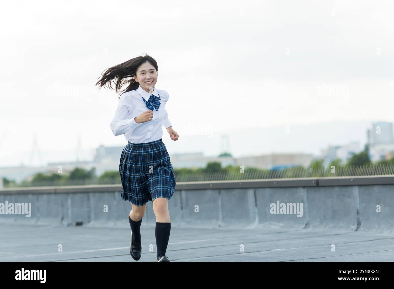 Female student running on rooftop Stock Photo - Alamy