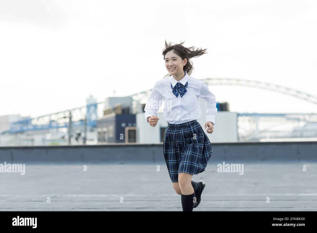 Female student running on rooftop Stock Photo - Alamy