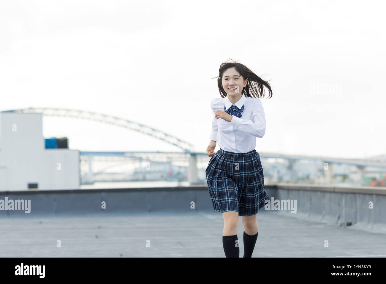 Female student running on rooftop Stock Photo - Alamy