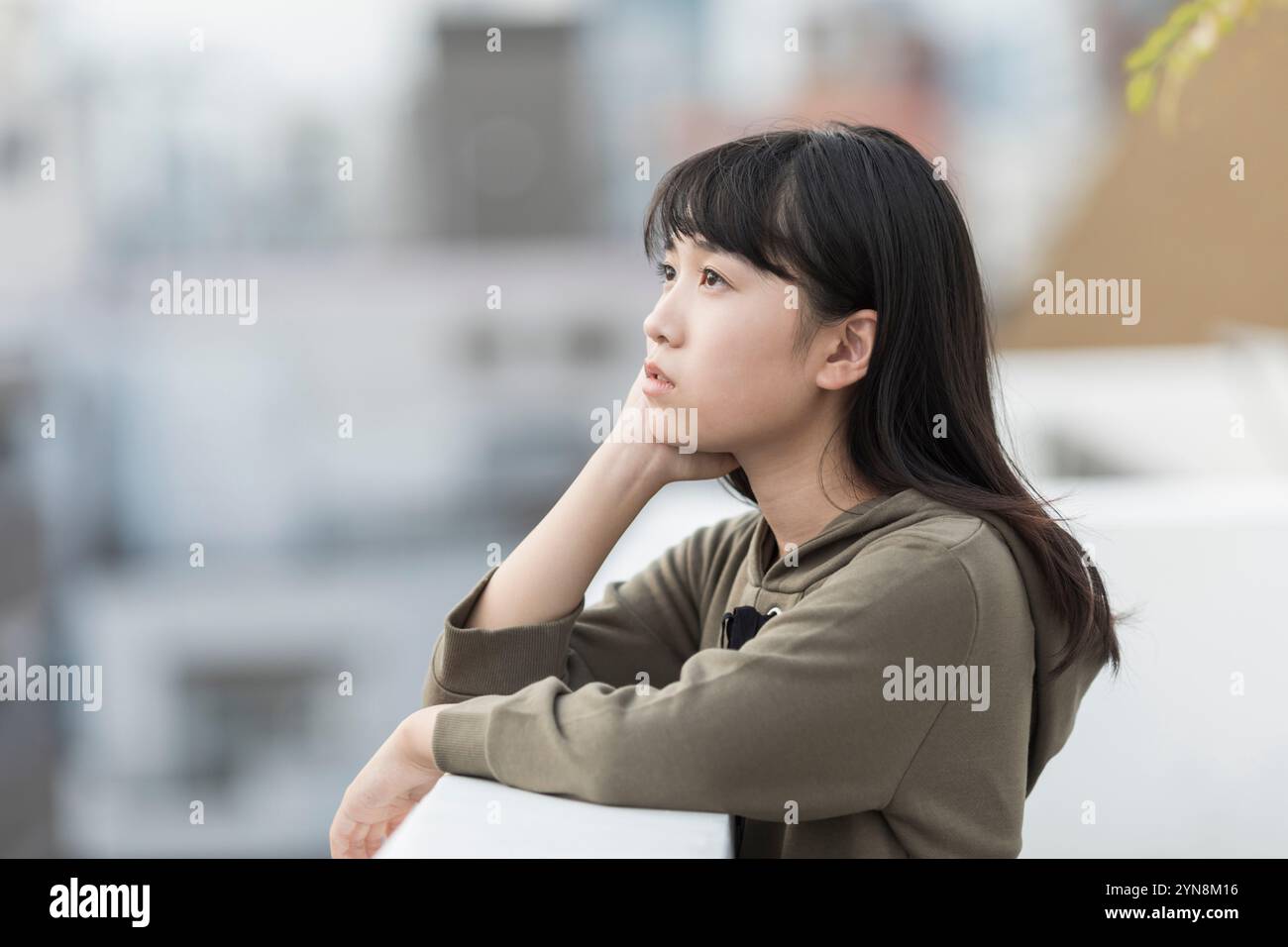 Girl looking out from balcony Stock Photo - Alamy