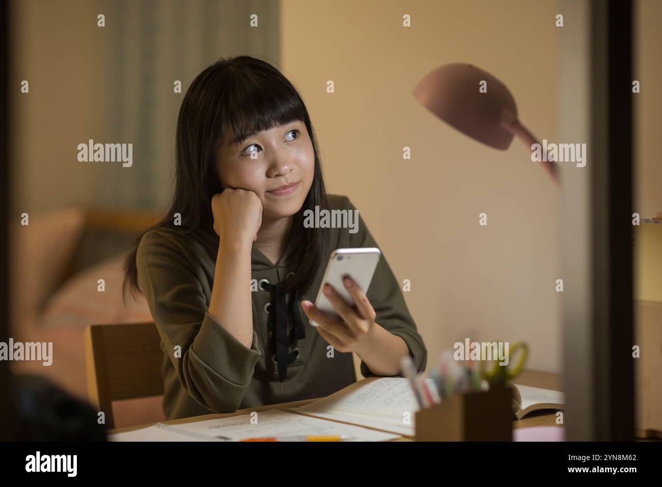 Girl studying while looking at her smartphone Stock Photo - Alamy