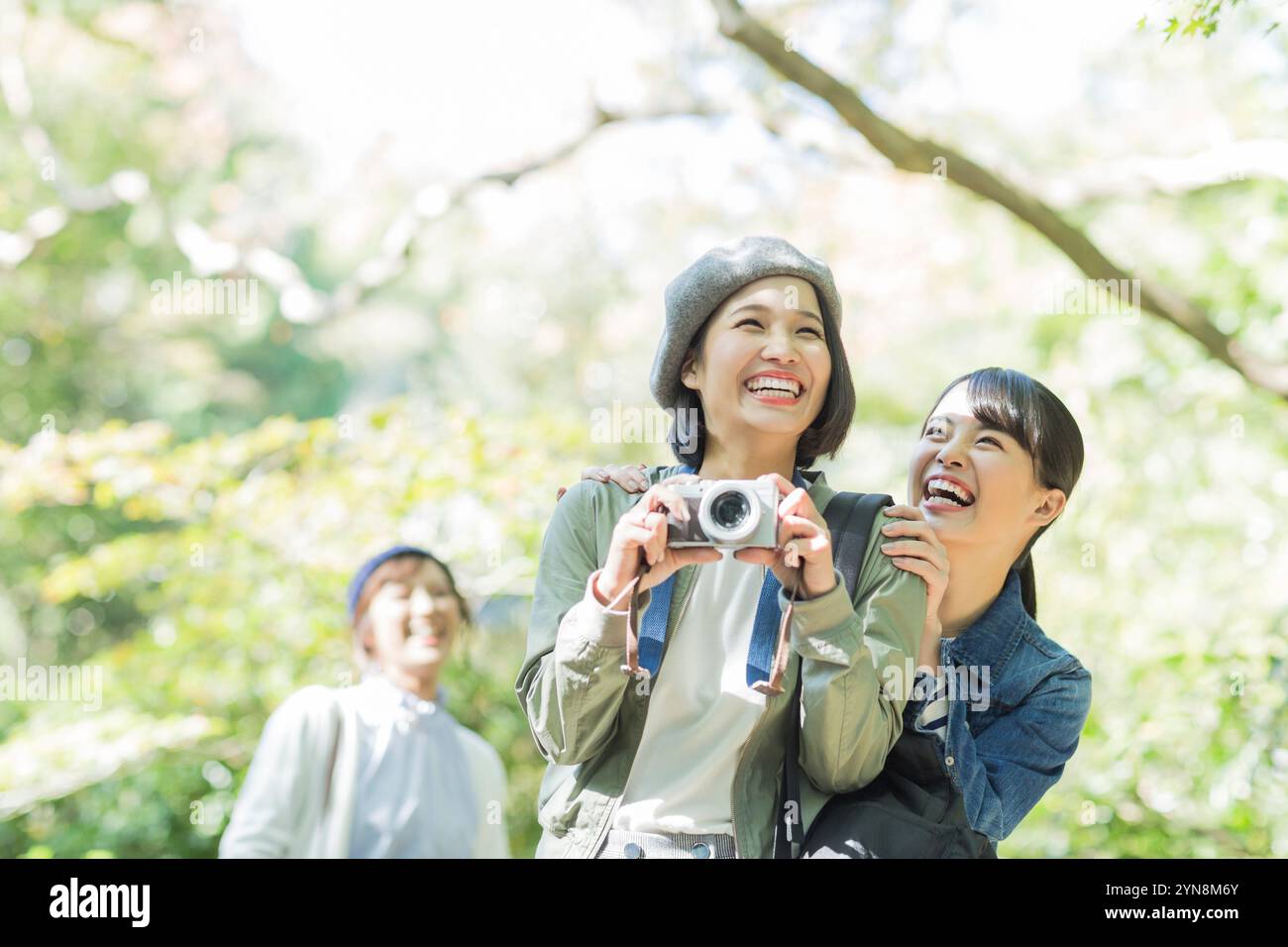 Three smiling women with camera Stock Photo - Alamy