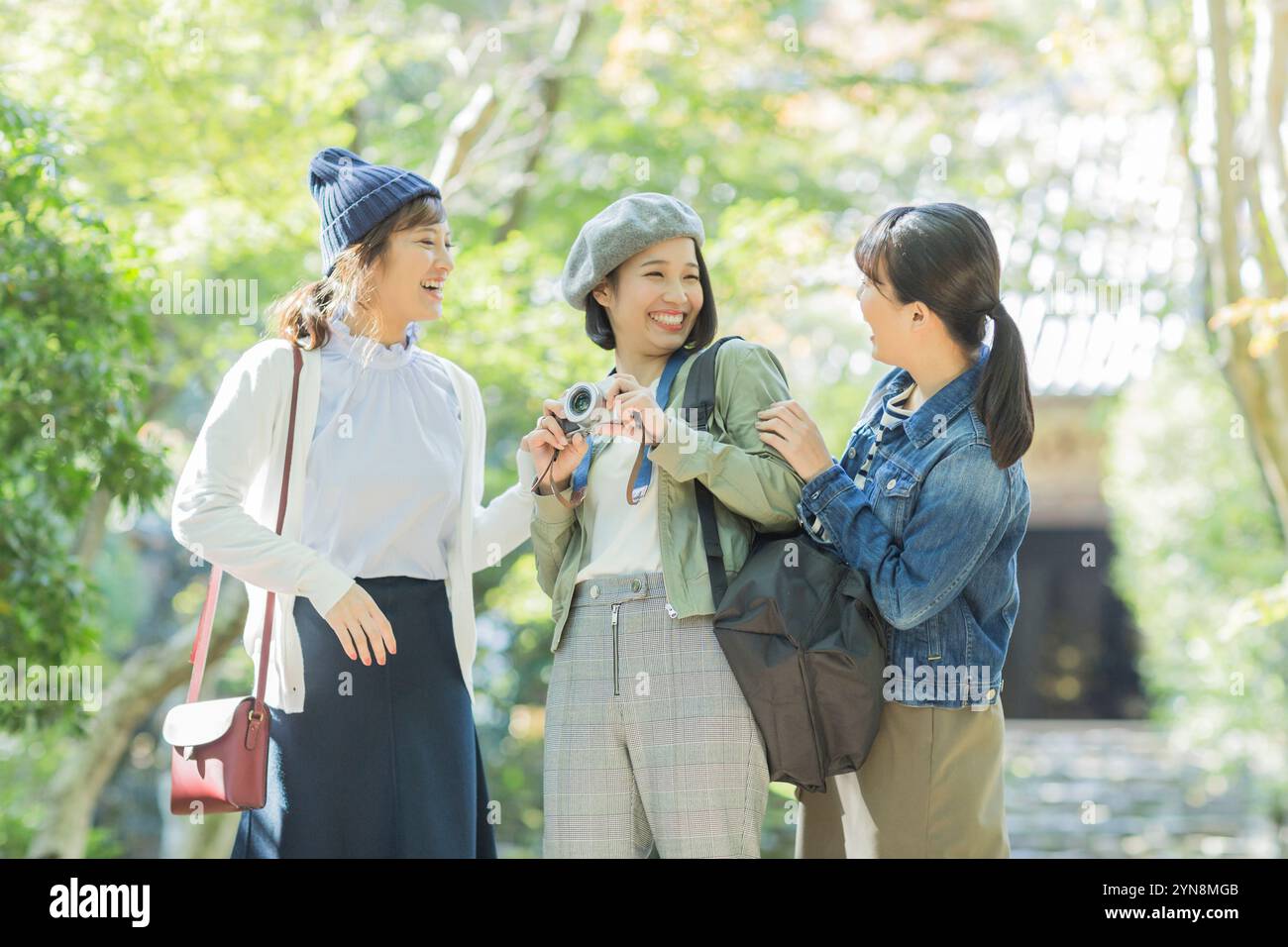 Three smiling women with camera Stock Photo - Alamy