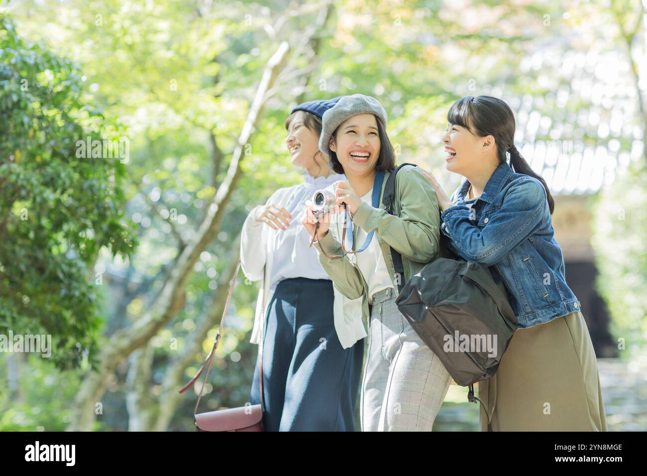Three smiling women with camera Stock Photo - Alamy