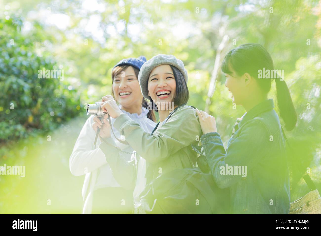Three smiling women with camera Stock Photo - Alamy