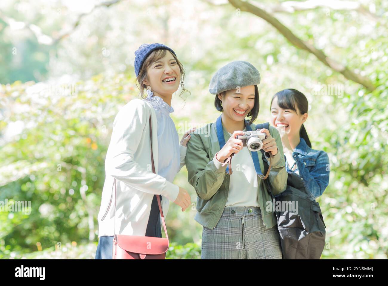 Three smiling women with camera Stock Photo - Alamy