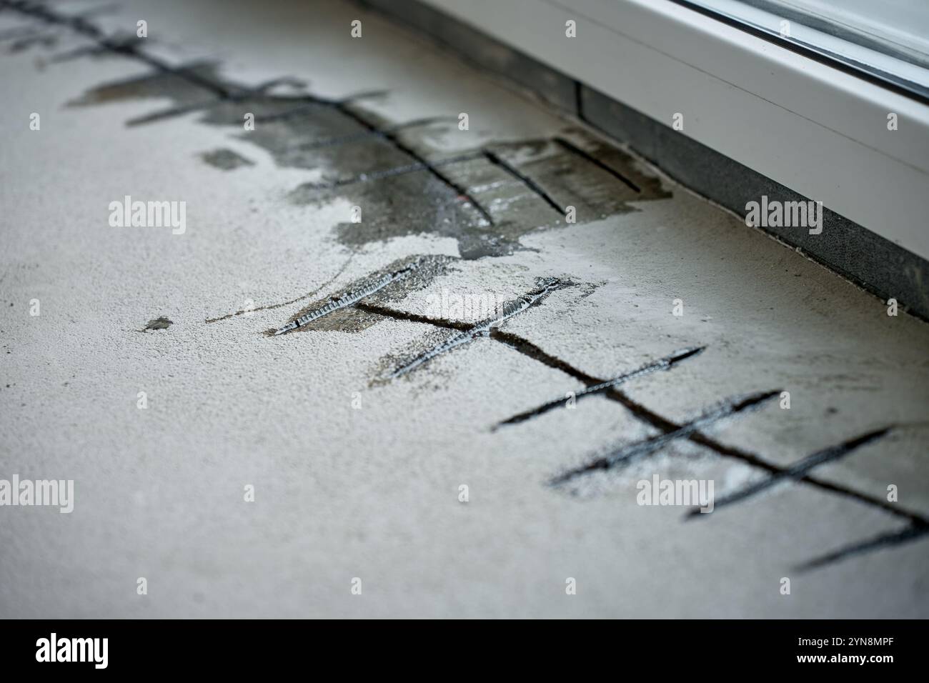 Repairing cracks in concrete floor near window using sealant ...