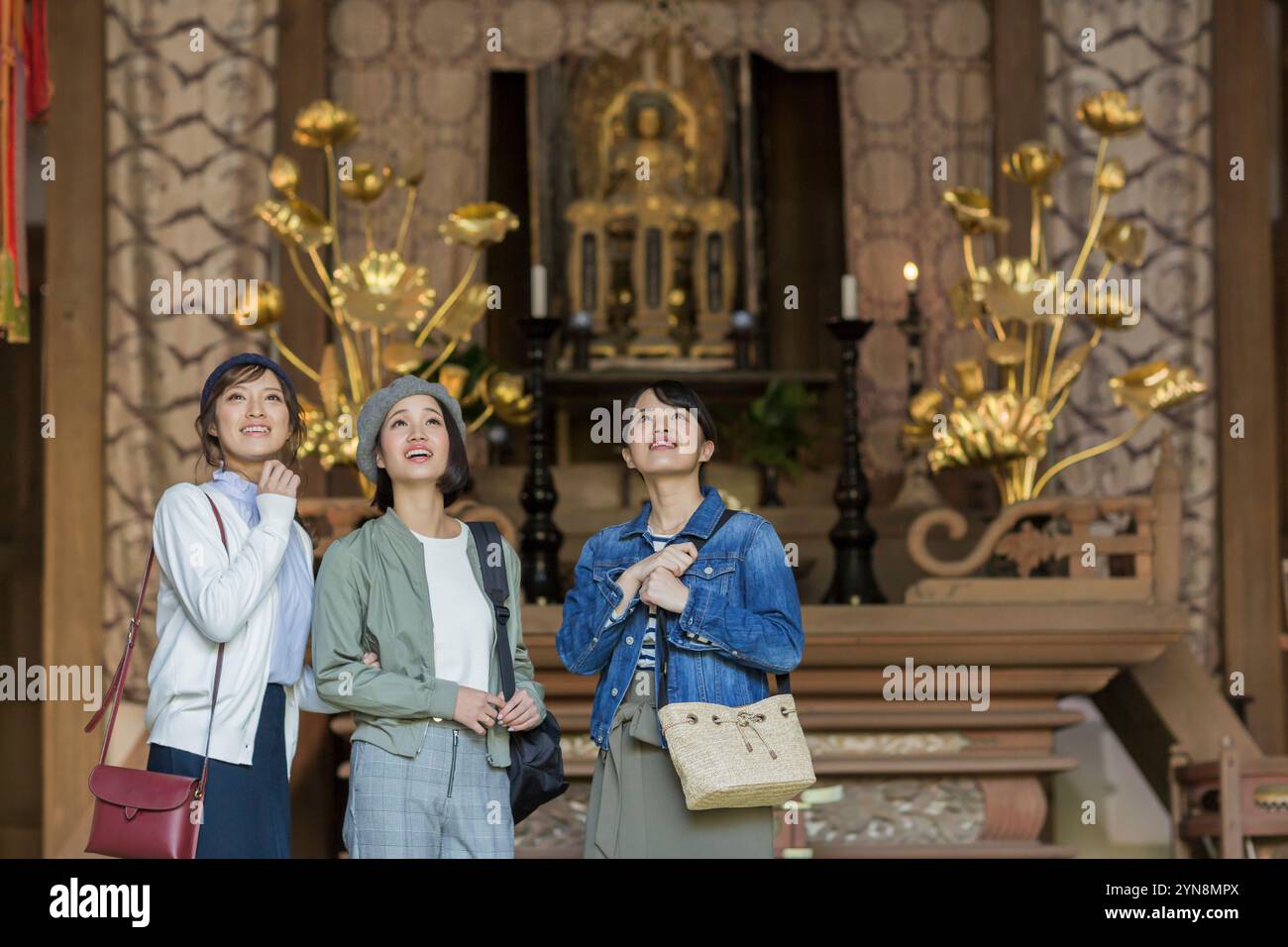 Three women touring the temple Stock Photo - Alamy