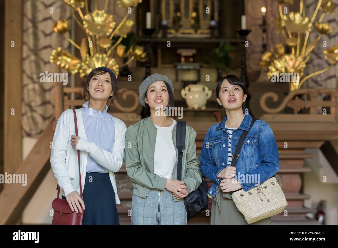 Three women touring the temple Stock Photo - Alamy