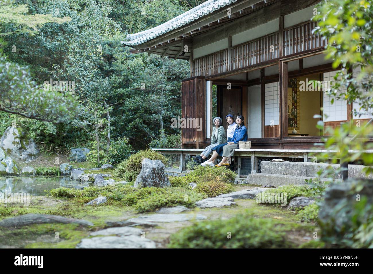 Three women sitting on the veranda Stock Photo - Alamy