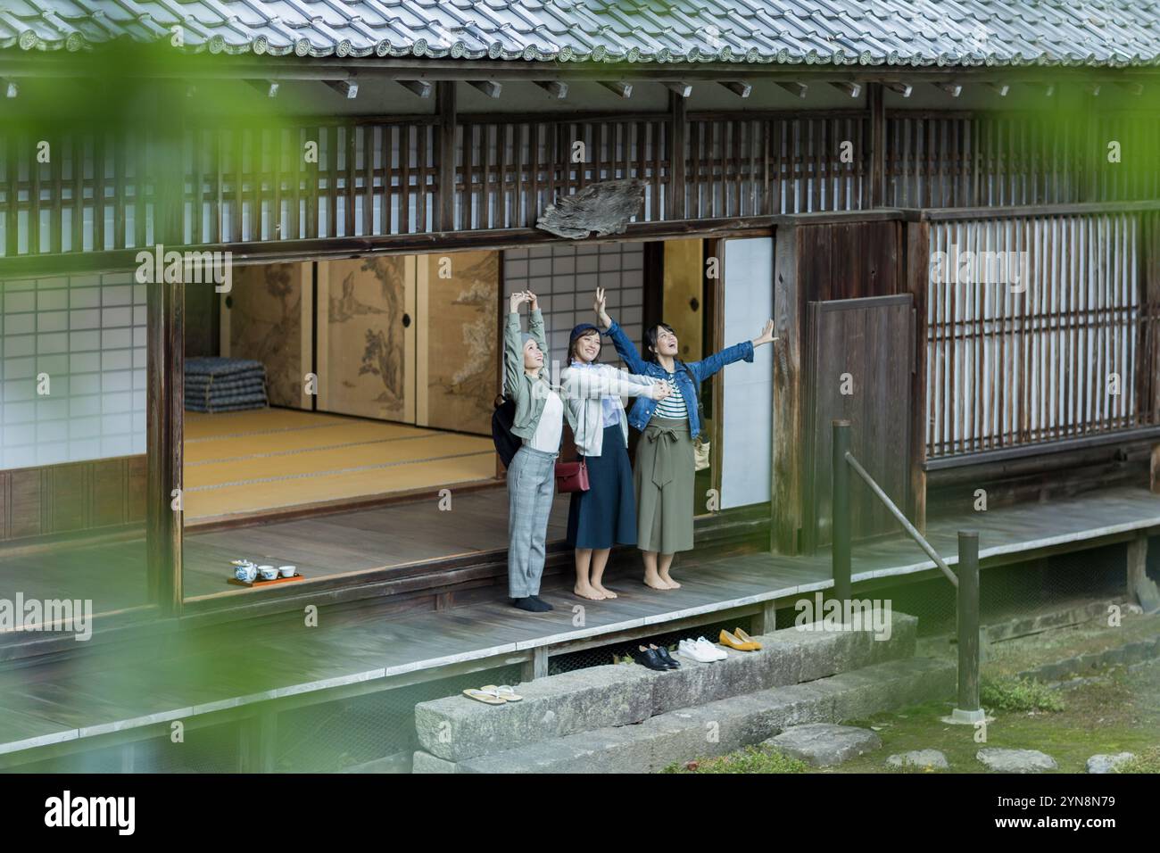 Three women standing on the veranda Stock Photo - Alamy