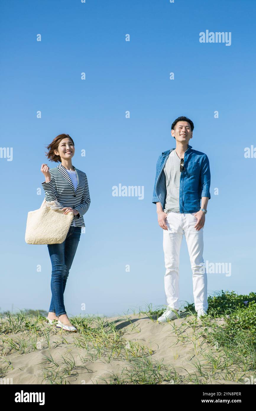 Blue sky and fresh couple in their 20s and 30s Stock Photo - Alamy