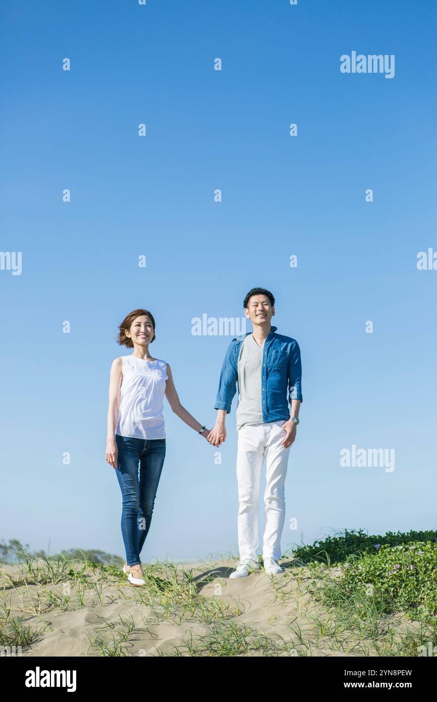 Blue sky and fresh couple in their 20s and 30s Stock Photo - Alamy