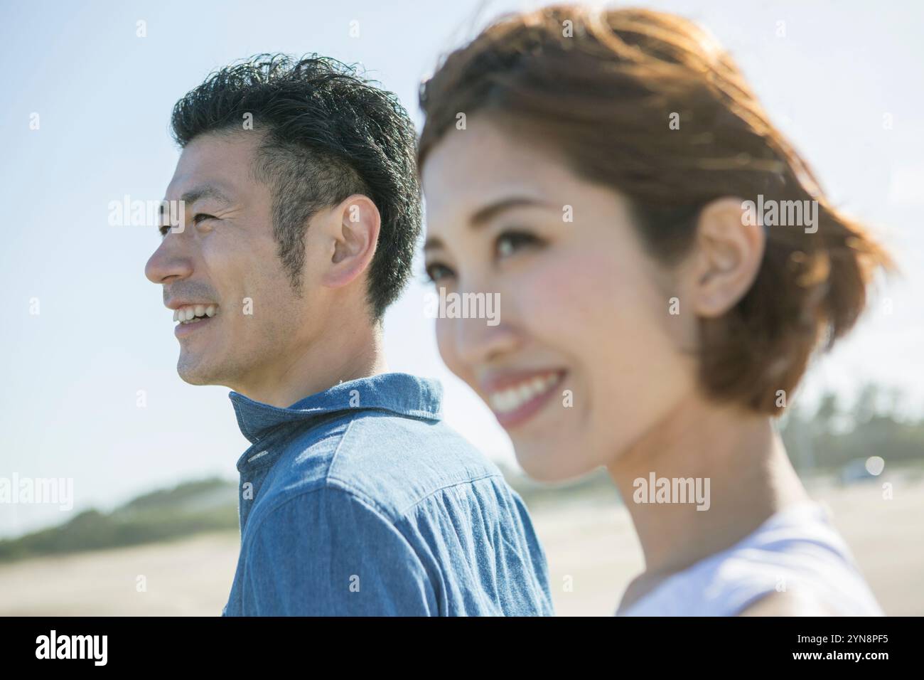 Blue sky and fresh couple in their 20s and 30s Stock Photo - Alamy