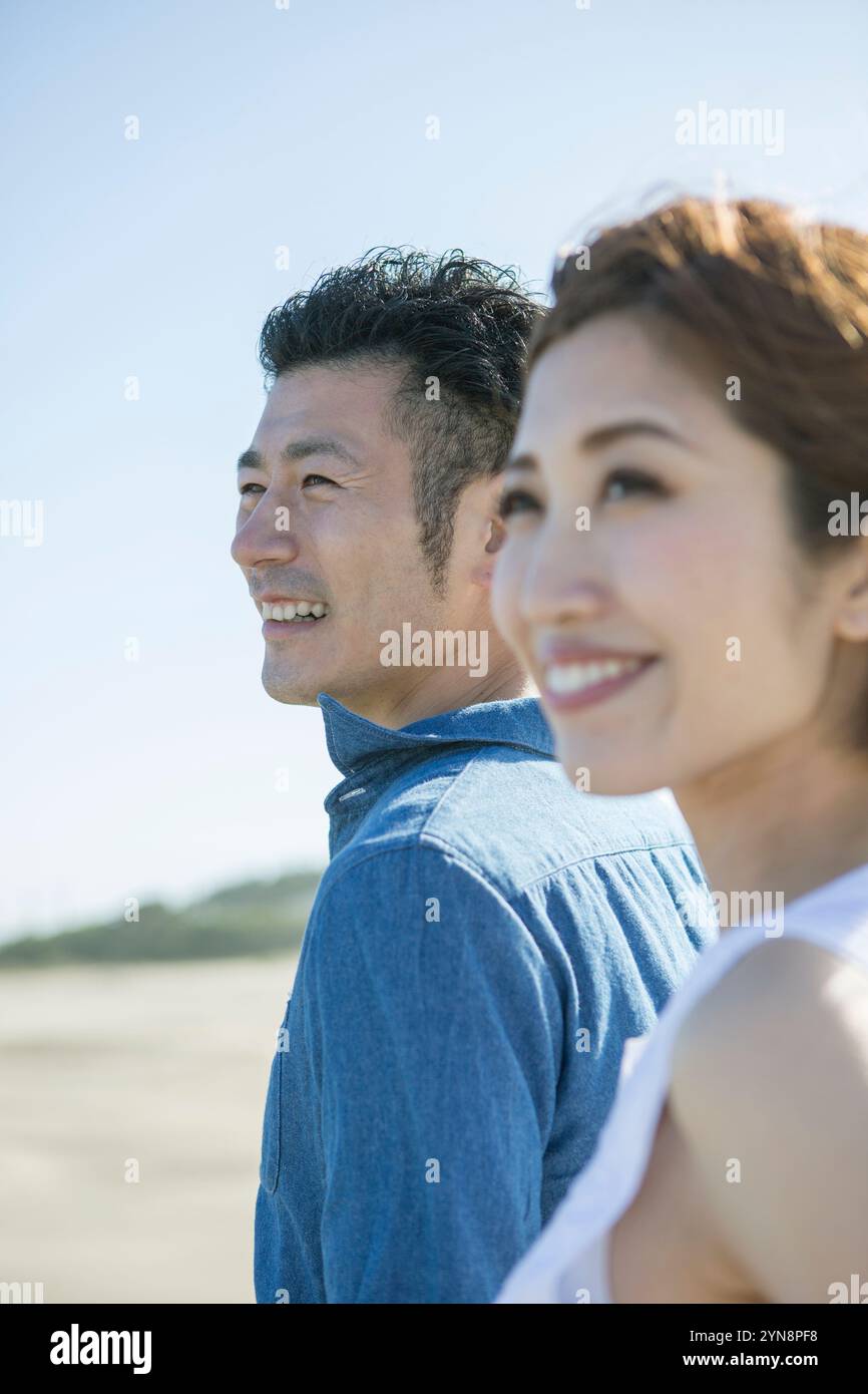 Blue sky and fresh couple in their 20s and 30s Stock Photo - Alamy