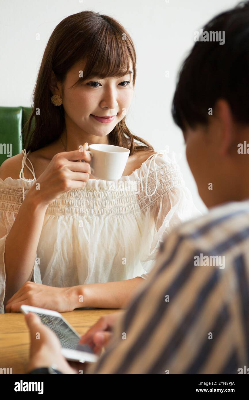 Couple in their 20s taking a break at a café Stock Photo - Alamy