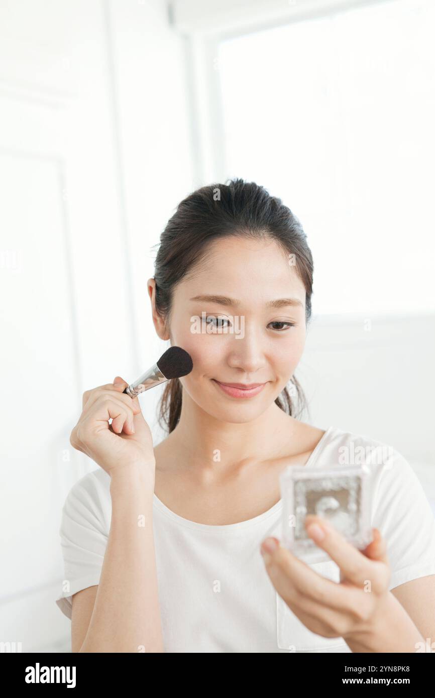 Woman putting on makeup in mirror hi-res stock photography and images ...