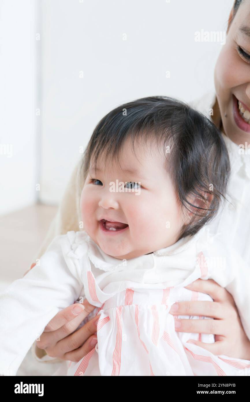 Baby being carried by mum Stock Photo - Alamy