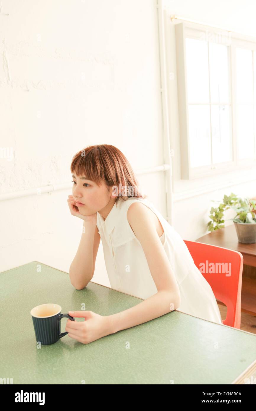 Woman in her 20s, resting on her elbows and thinking about something ...