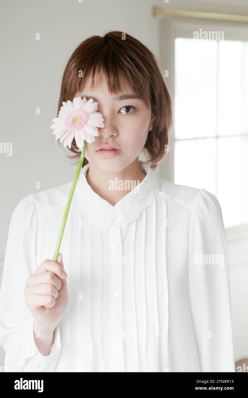 Woman covering an eye with flower hi-res stock photography and images ...