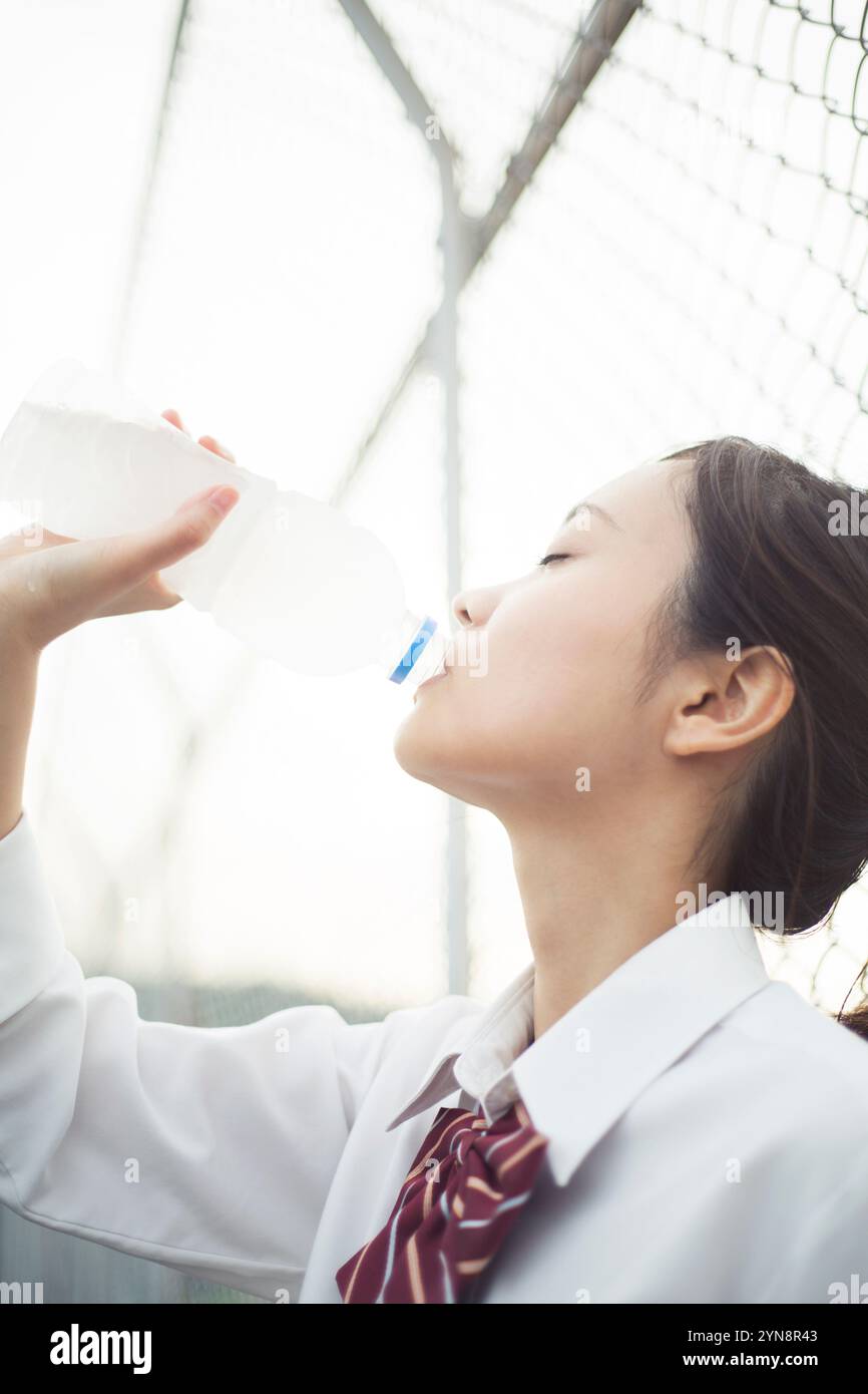 High school girl drinking from a plastic bottle Stock Photo - Alamy