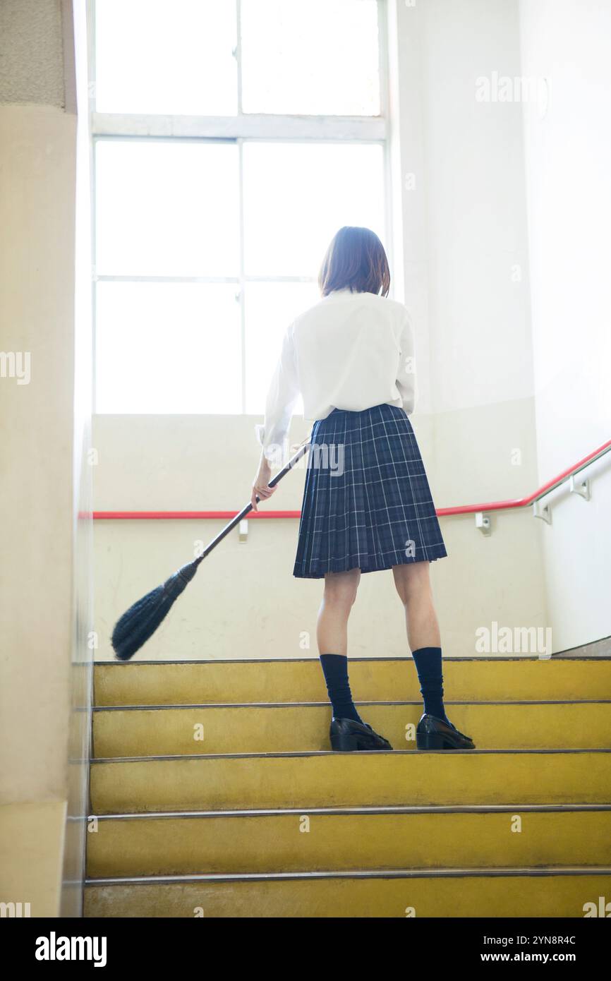Back view of high school girls cleaning the corridor Stock Photo - Alamy